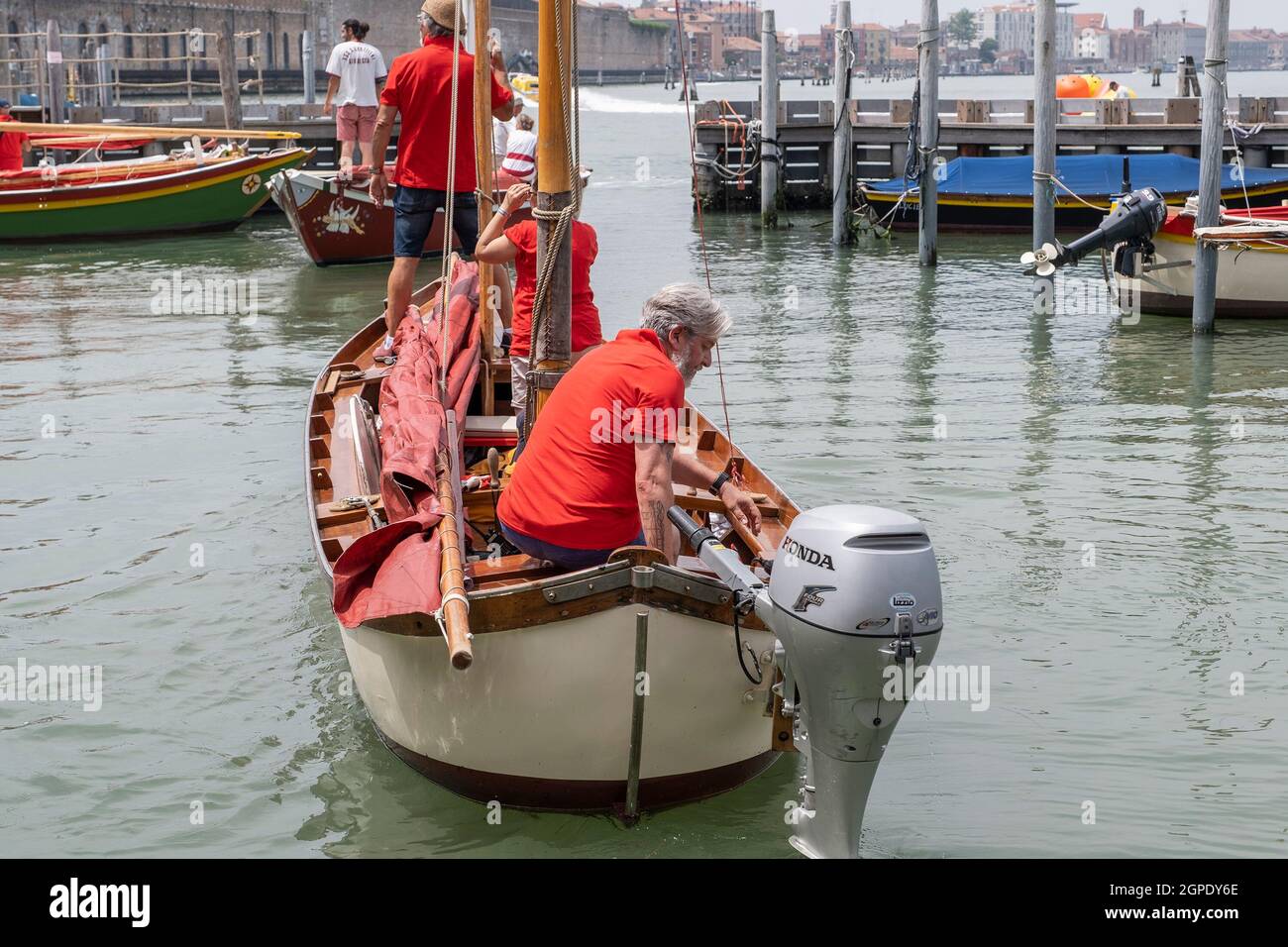VENICE, ITALY - JUNE 20: Red regatta participants sail in the lagoon ...