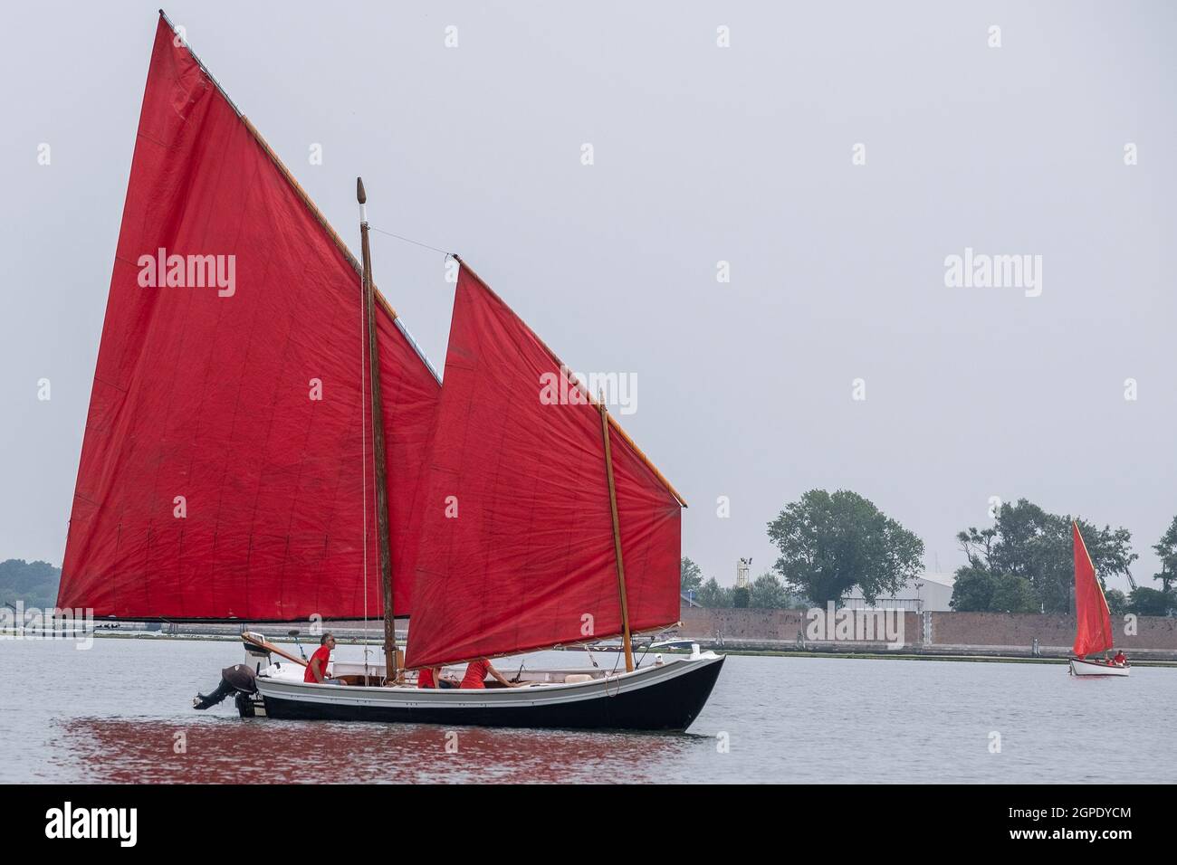 VENICE, ITALY - JUNE 20: Red regatta participants sail in the lagoon ...