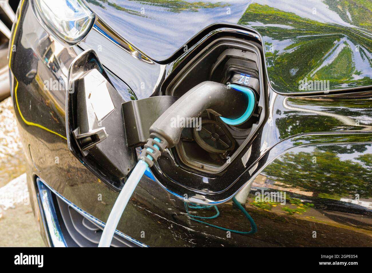 Cable plugged into an electric vehicle at a car charging station Stock ...