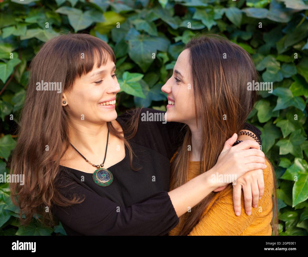 Outdoor portrait of two happy sisters relaxed in a park Stock Photo - Alamy