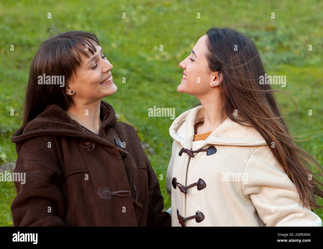 Outdoor portrait of two happy sisters relaxed in a park Stock Photo - Alamy