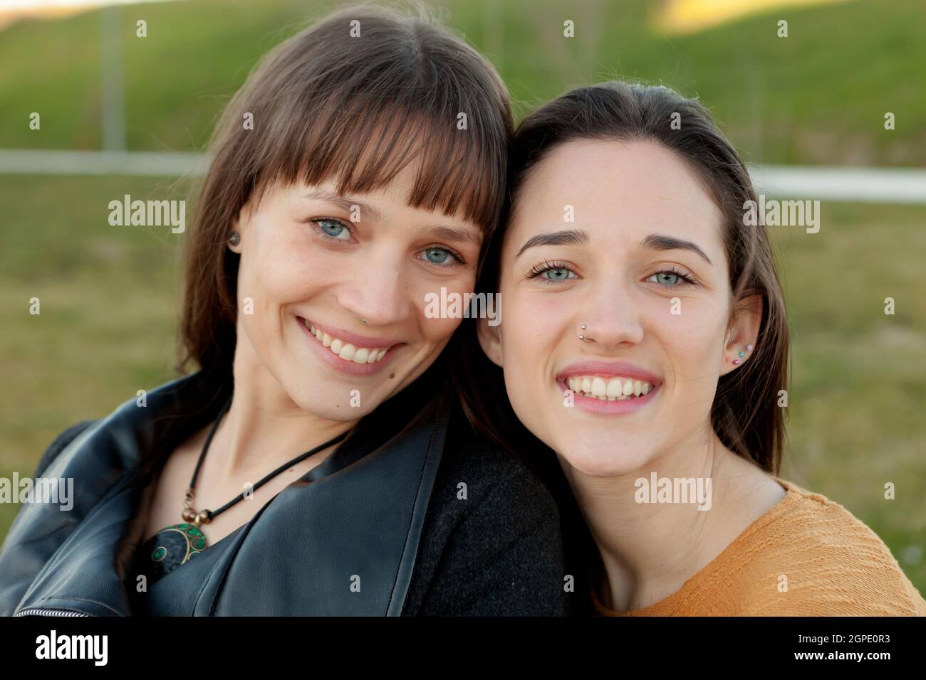 Outdoor portrait of two happy sisters relaxed in a park Stock Photo - Alamy