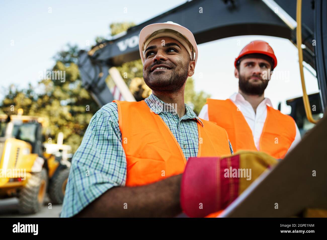 Two men engineers discussing their work standing against construction ...