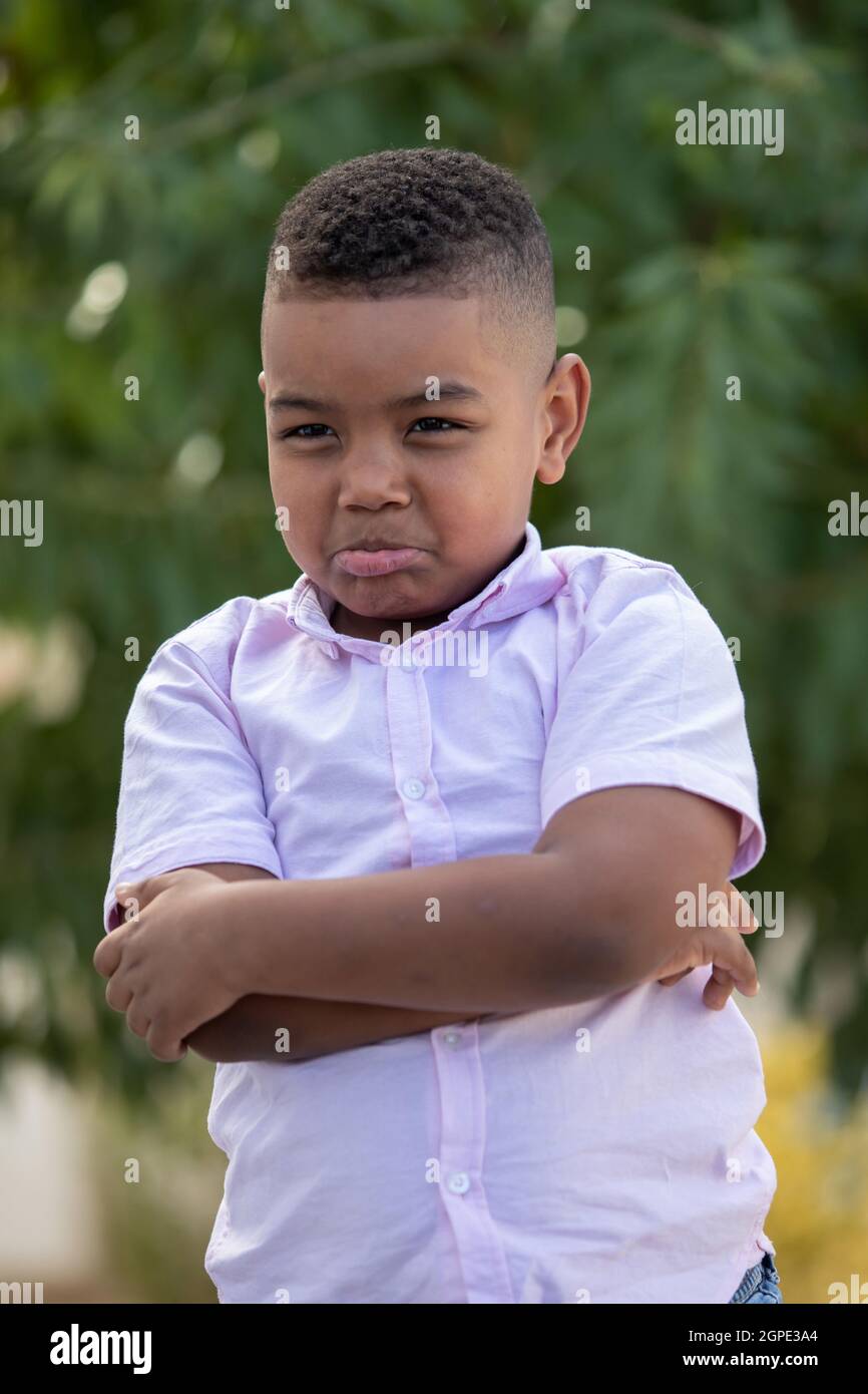 Angry latin child in a day in the park Stock Photo - Alamy