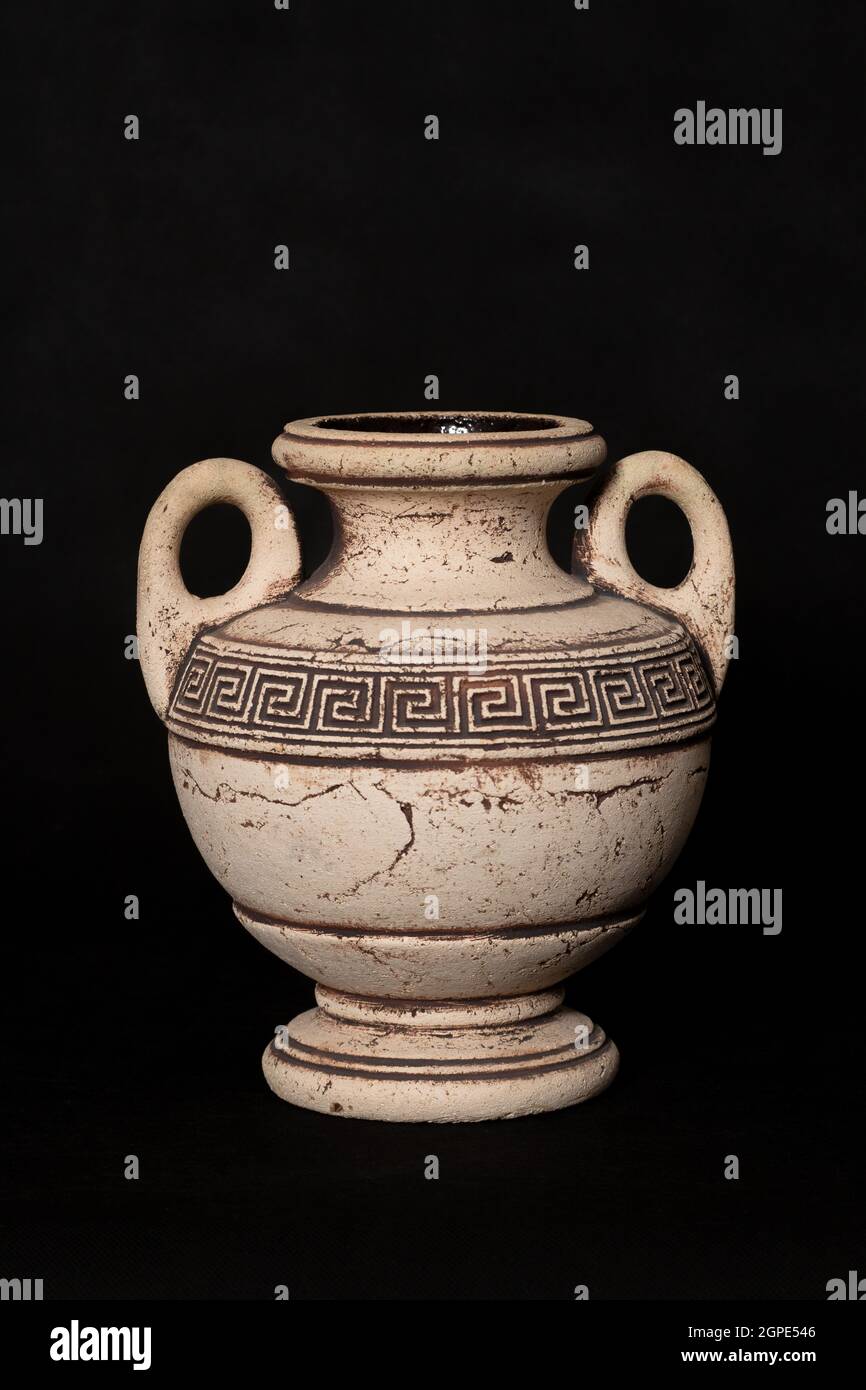 Clay light amphora stands on a black background vertically in the room ...