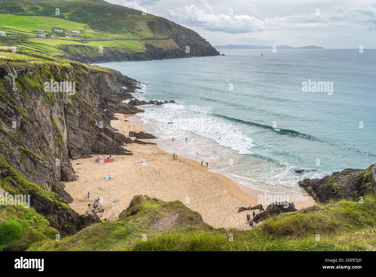 People swimming in turquoise coloured see and families relaxing on ...