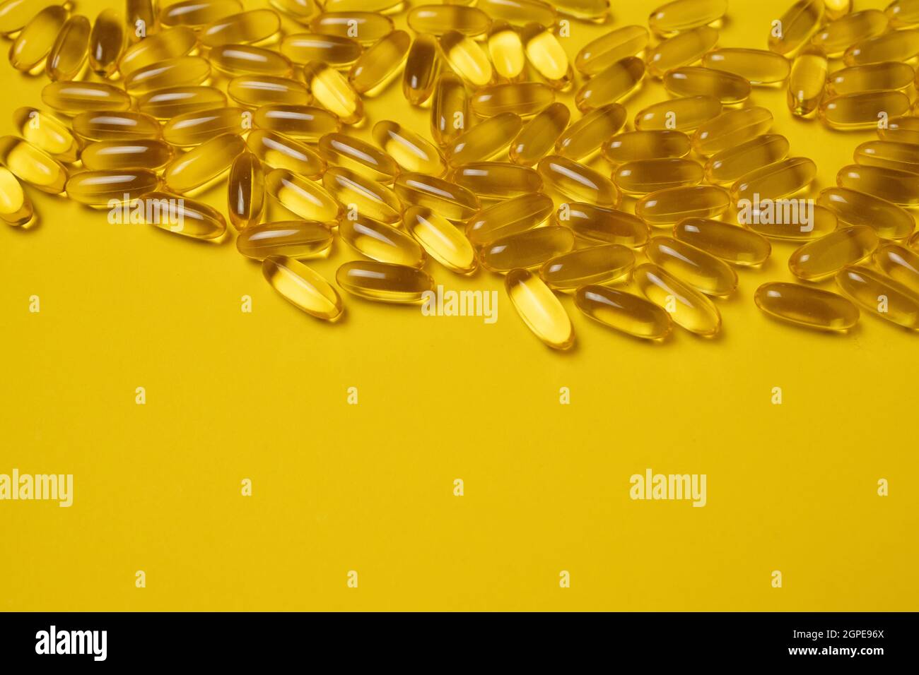 Fish oil omega 3 gel capsules isolated on yellow background. Bunch of ...