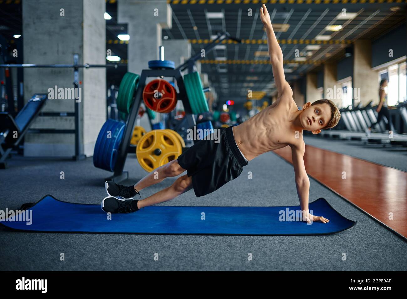 Boy doing fitness exercise on mat in gym. Youngster on training in ...