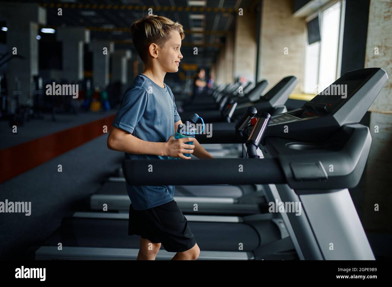 Boy doing exercise on treadmill in gym, running machine. Schoolboy on ...