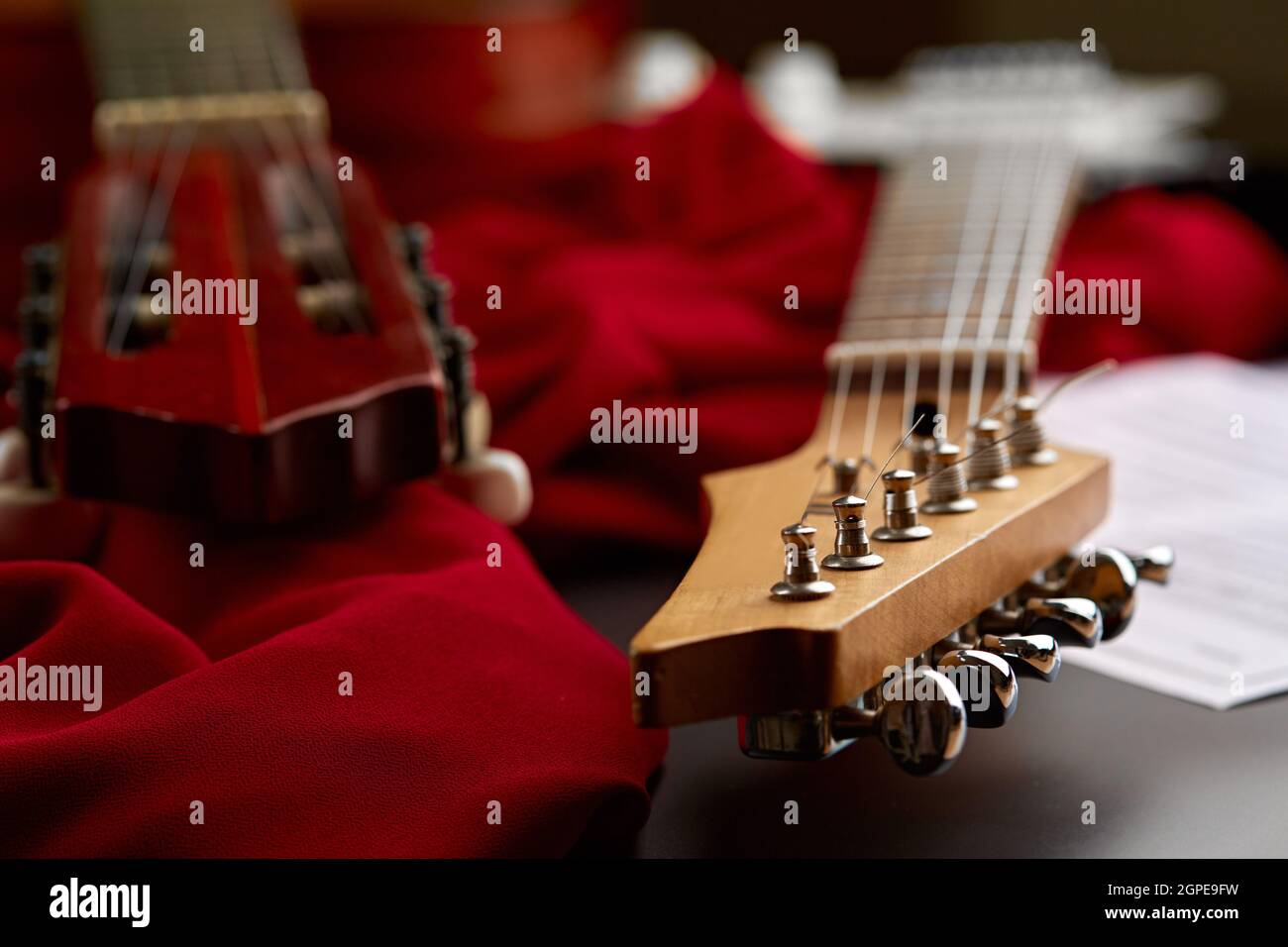 Modern electric and classical acoustic guitar heads closeup, black ...