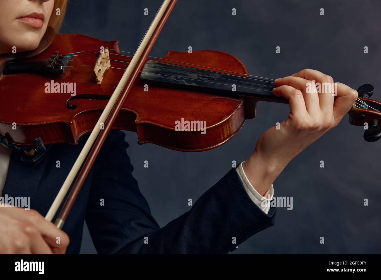 Female violonist with bow and violin, performance on stage. Woman with ...
