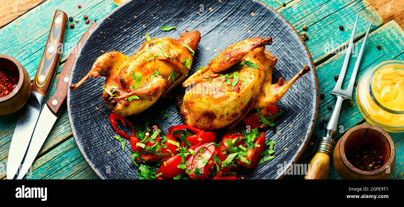 Roasted whole quail and spring vegetable salad.Appetizing baked quail ...