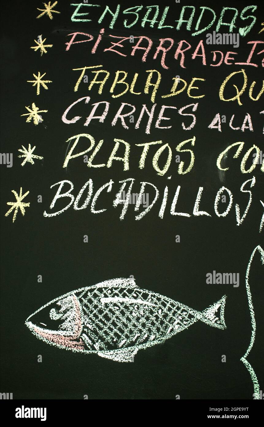 Restaurant menu board offering food with colorful drawings. Spanish ...