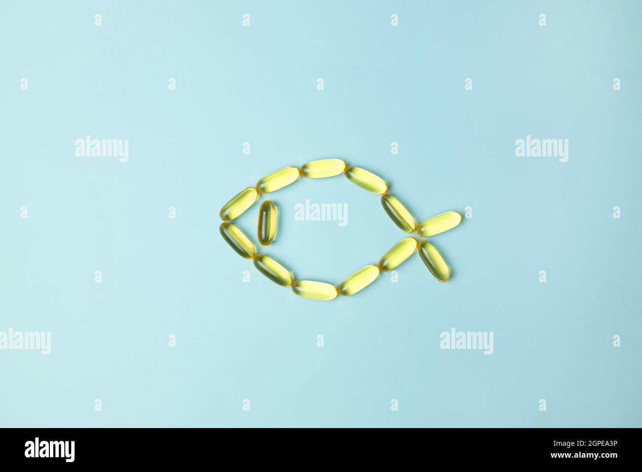 Omega 3 capsules - fish shape isolated on blue background. Healthy and ...