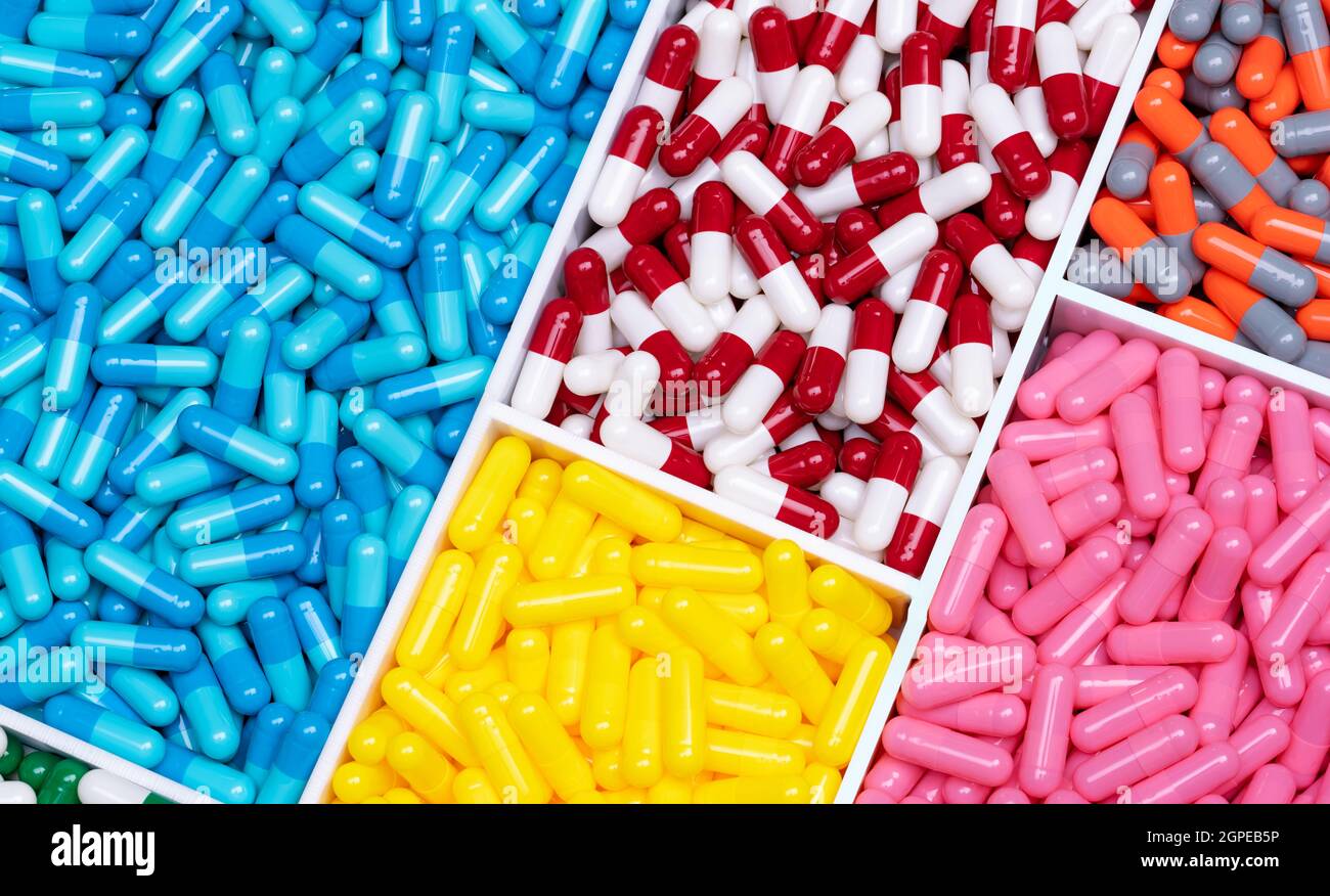 Multi-colored capsule pills in plastic drug tray. Pharmacology ...