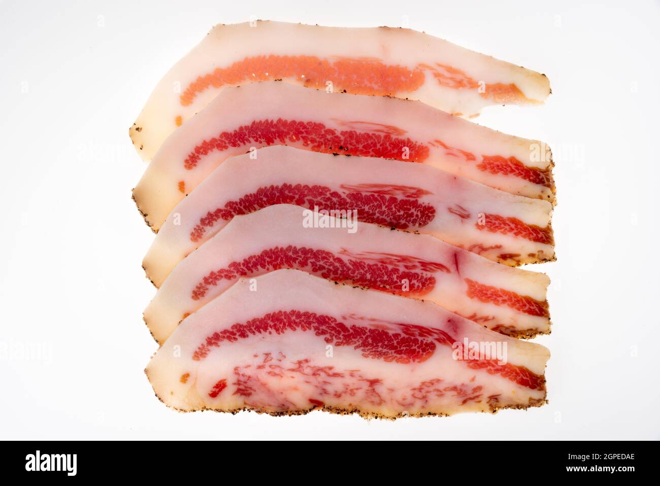 Italian Guanciale, slices dry cured pork cheek isolated on white in top ...