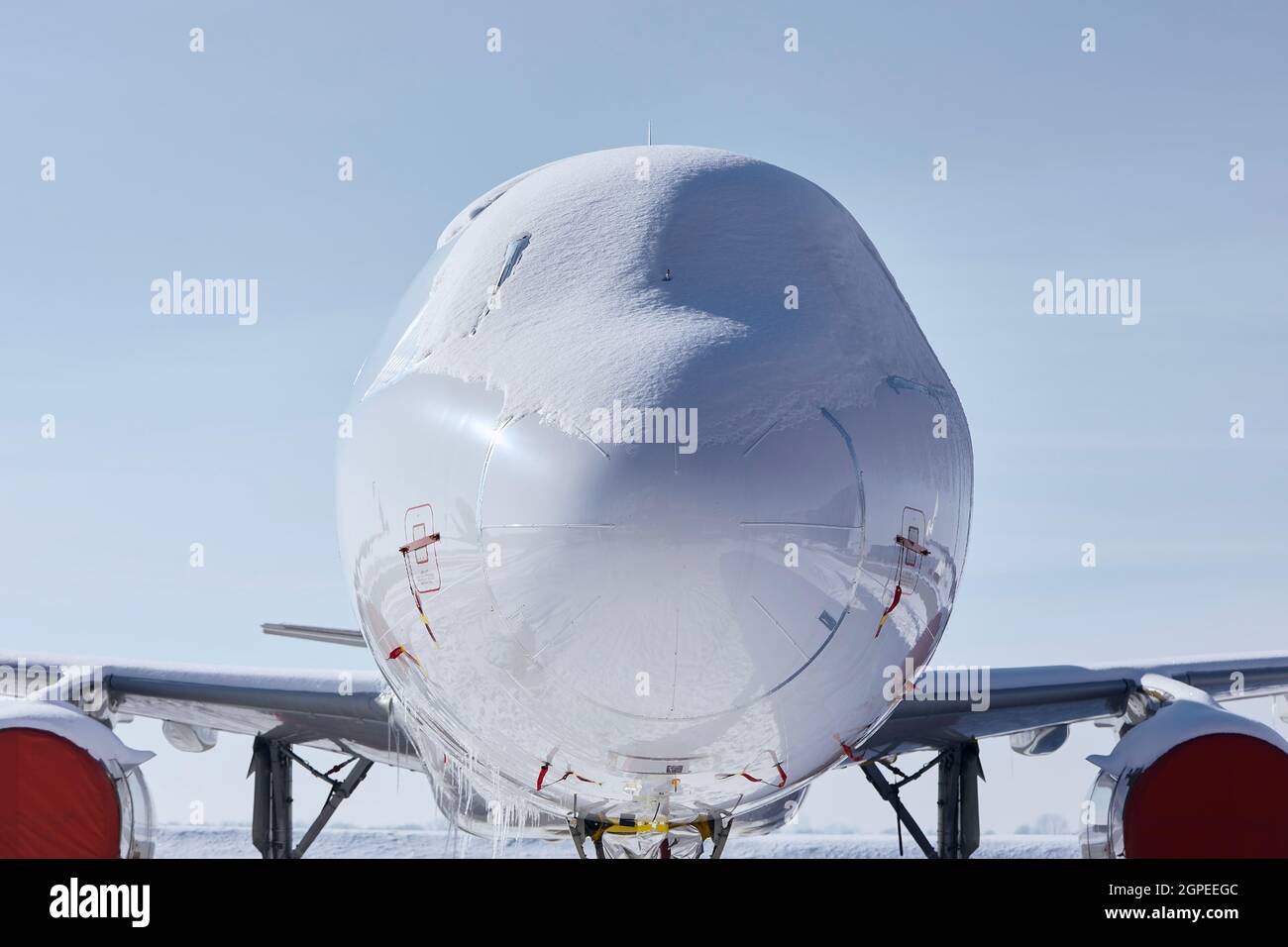 Snow covered cockpit of commercial airplane. Front view of plane after ...