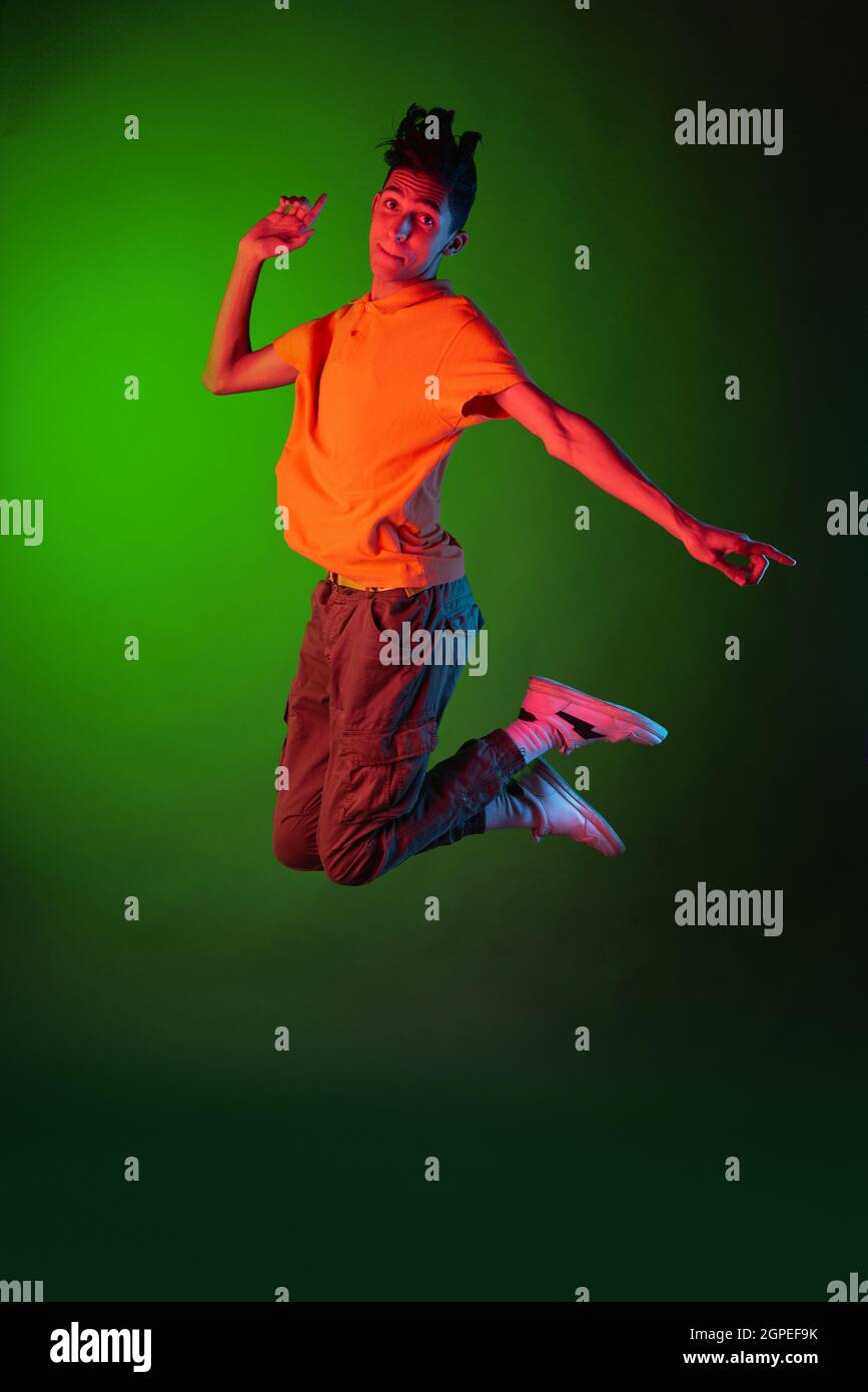 Portrait of young man, student in casual clothes jumping isolated on ...