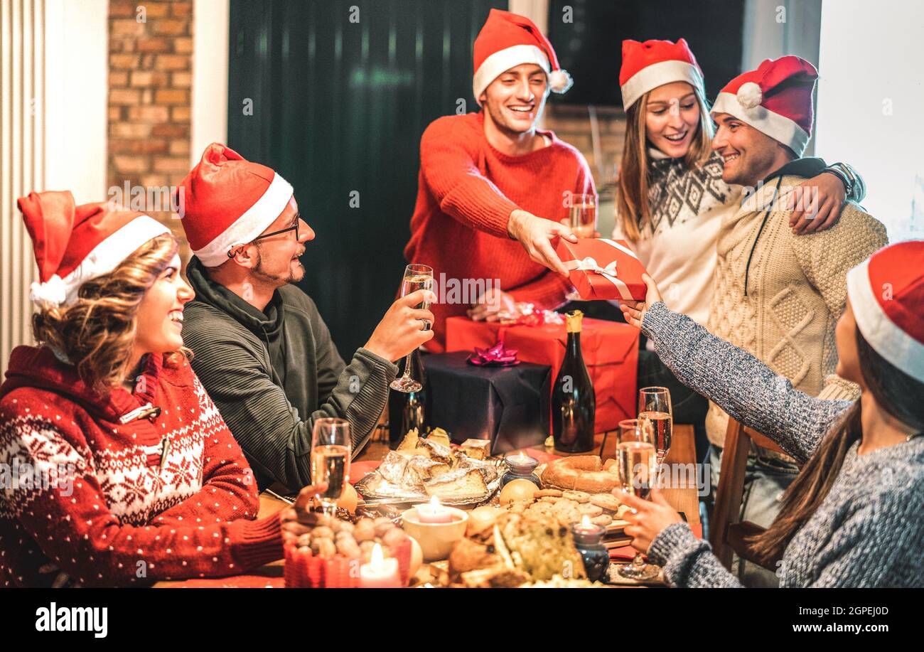 Friends group wearing santa hat giving each other Christmas presents ...