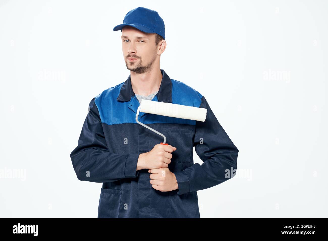 man in working uniform paint roller repair work Stock Photo - Alamy