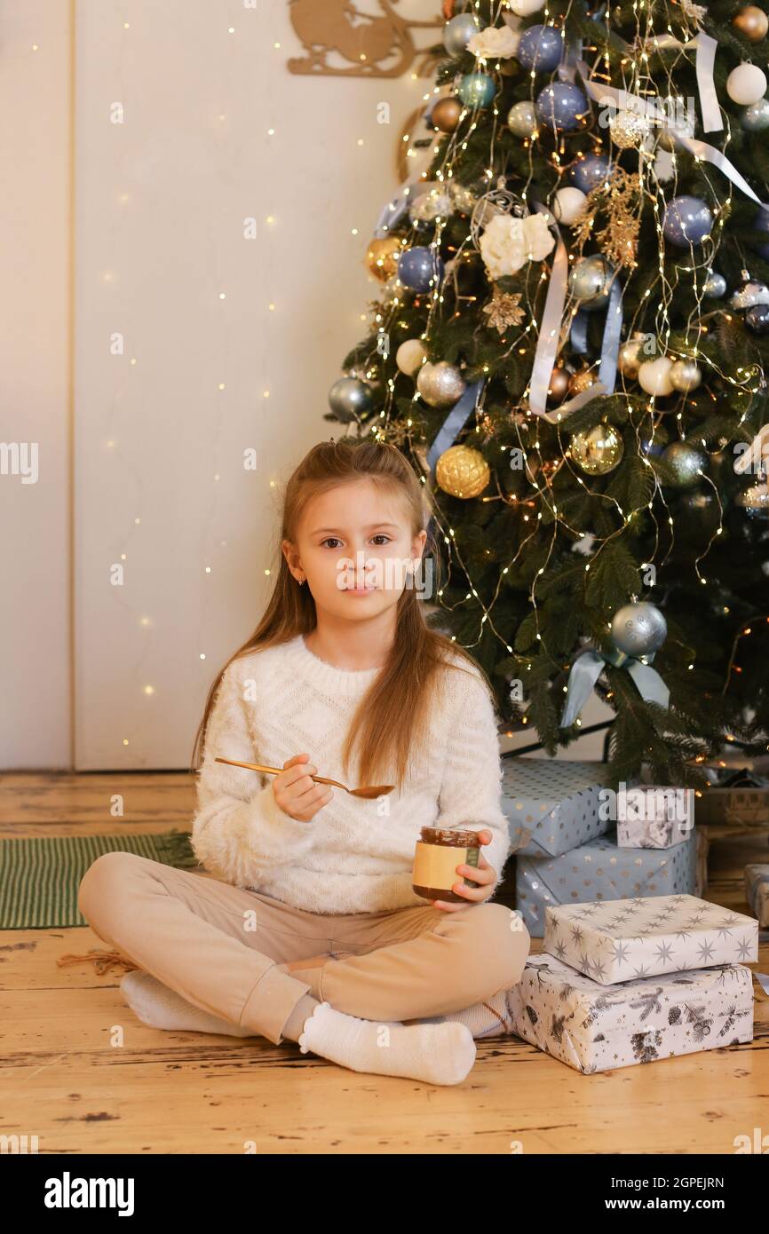 A young girl eat peanut butter on Holiday Christmas background Stock ...