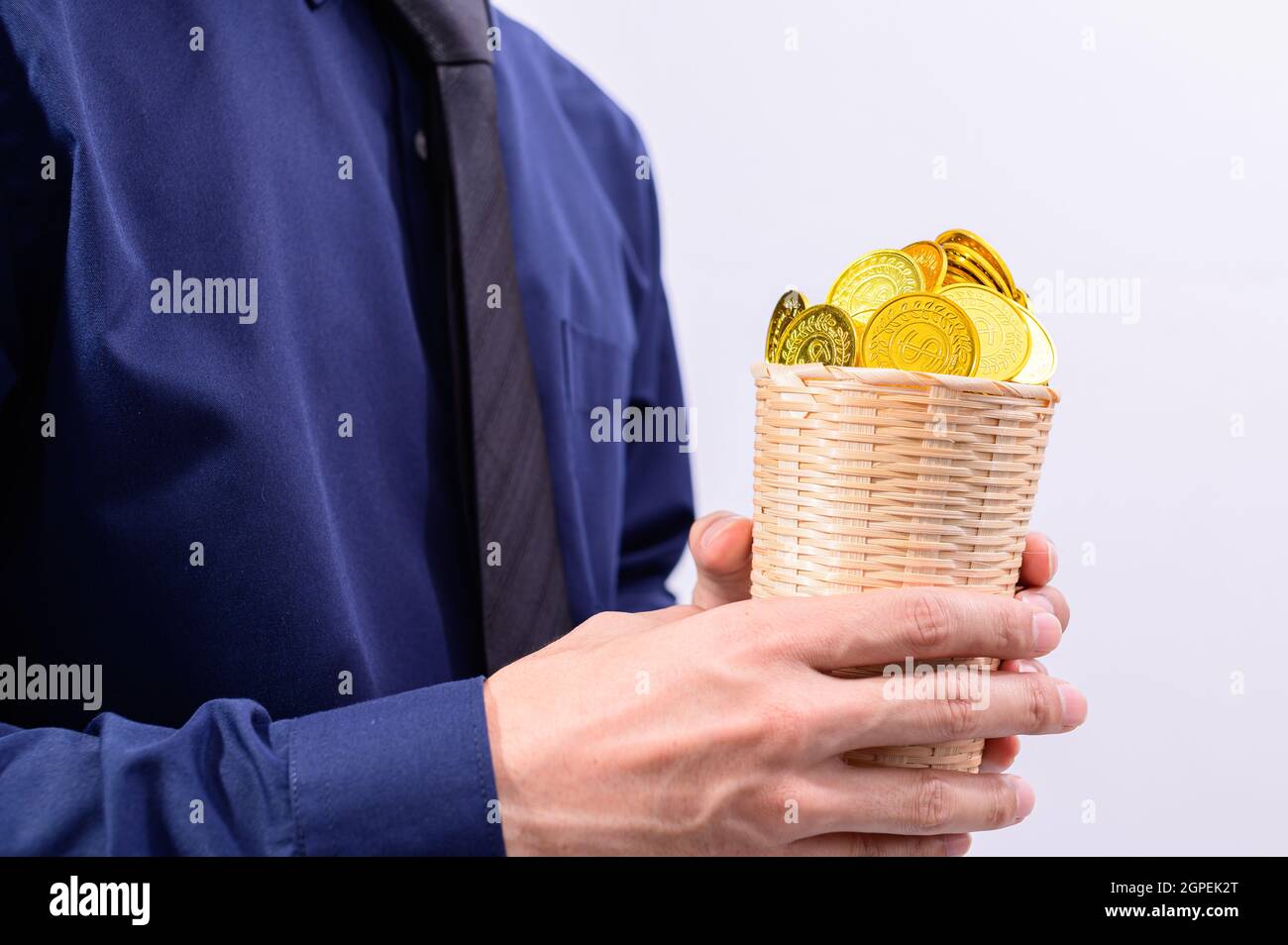 Hand holding a basket full of money Stock Photo - Alamy