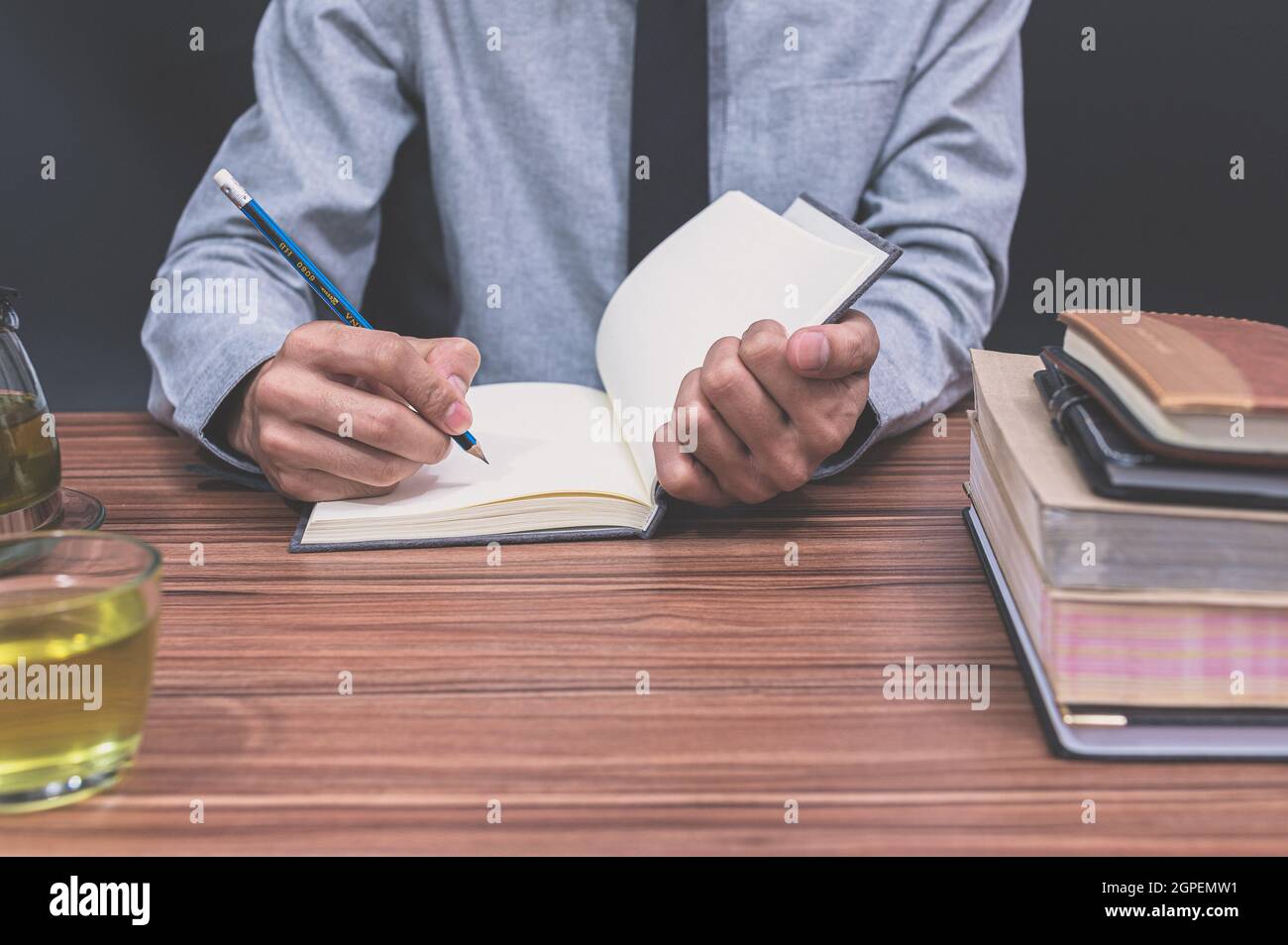 A man is writing at his desk Stock Photo - Alamy