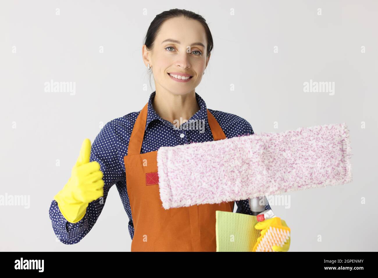 Smiling woman cleaning lady holds thumbs up Stock Photo - Alamy
