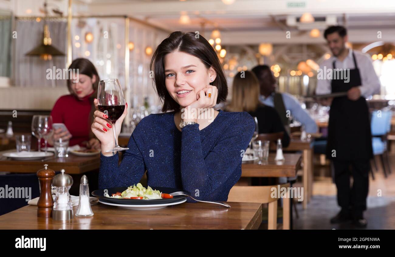 Happy girl alone in restaurant Stock Photo - Alamy
