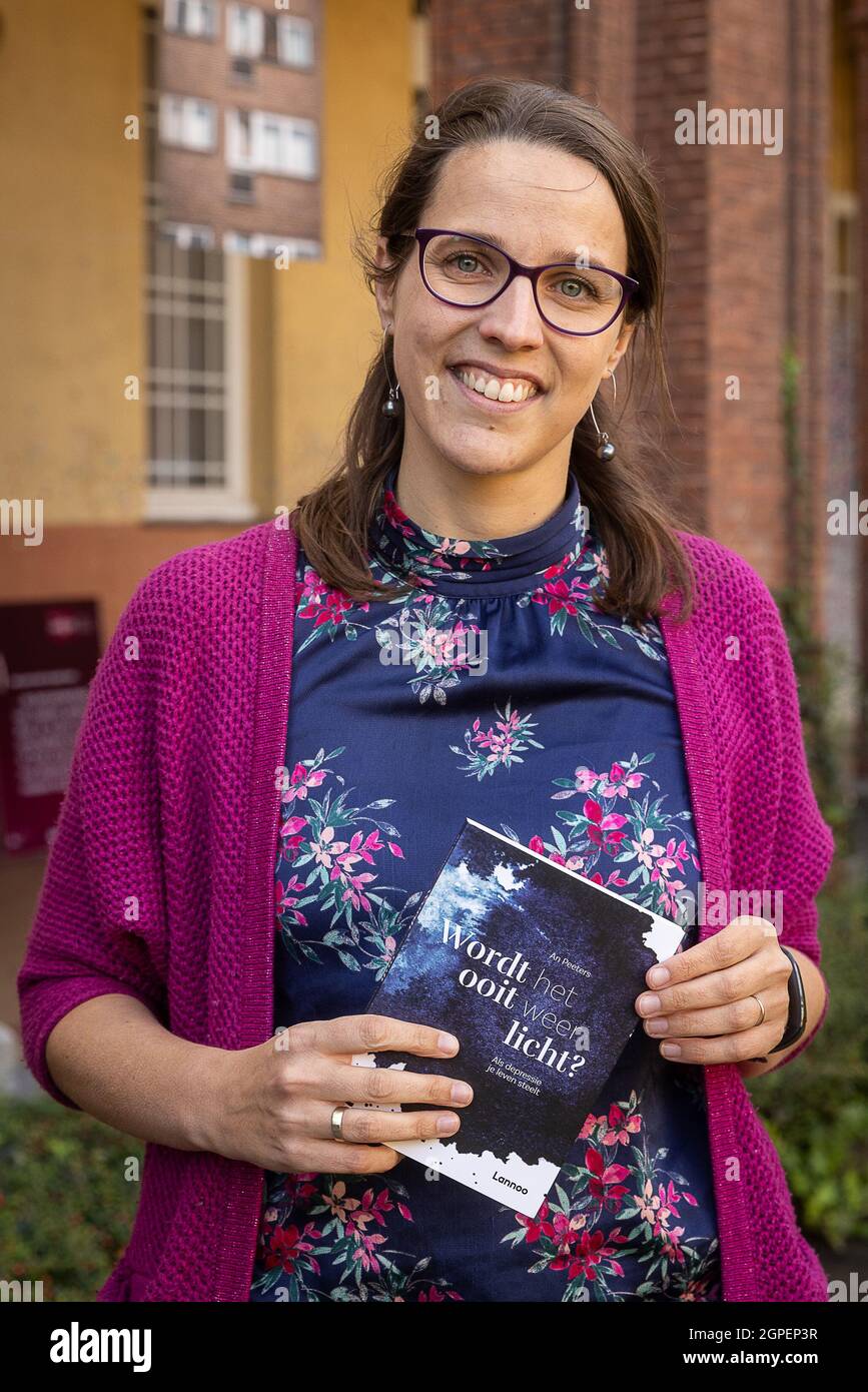 Writer An Peeters holds her new book 'Wordt het ooit nog licht' as she ...