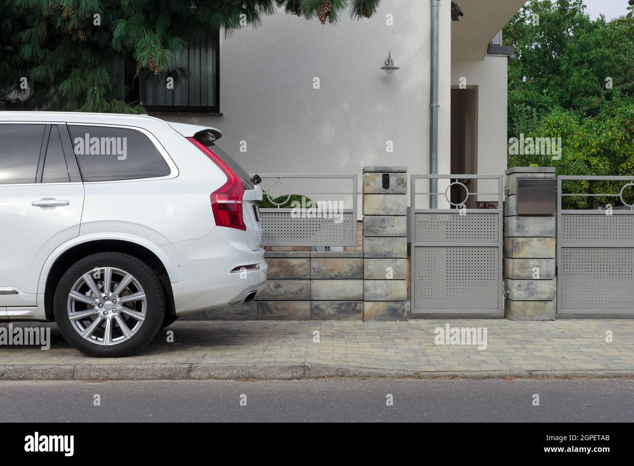 White car at the gate of a modern residential building Stock Photo - Alamy