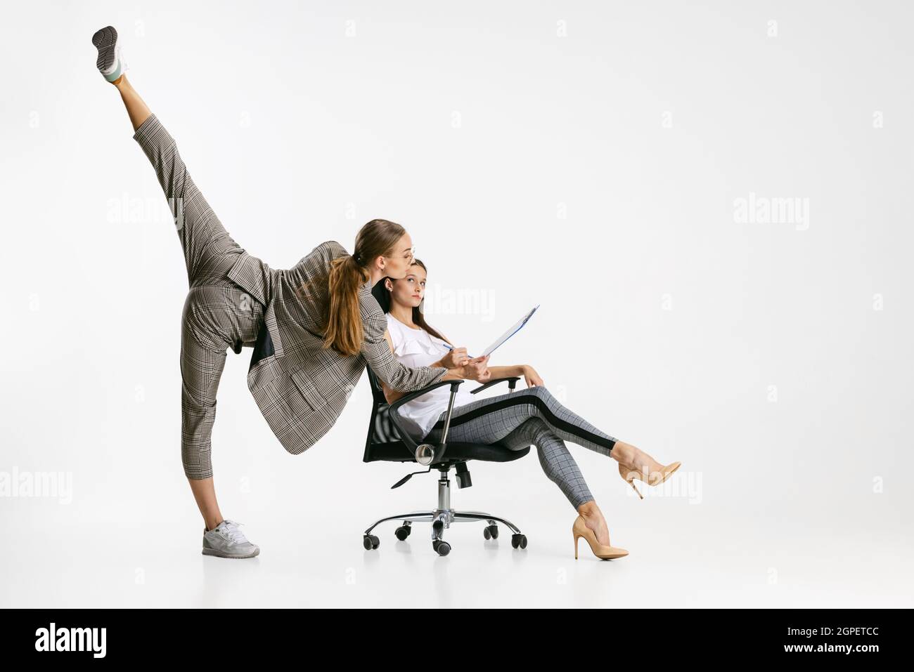 Two women, employees in casual clothes at office isolated over white ...