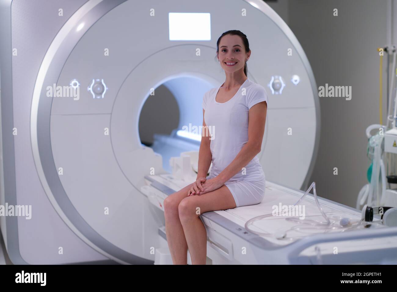 Young female patient sitting in magnetic resonance imaging machine ...