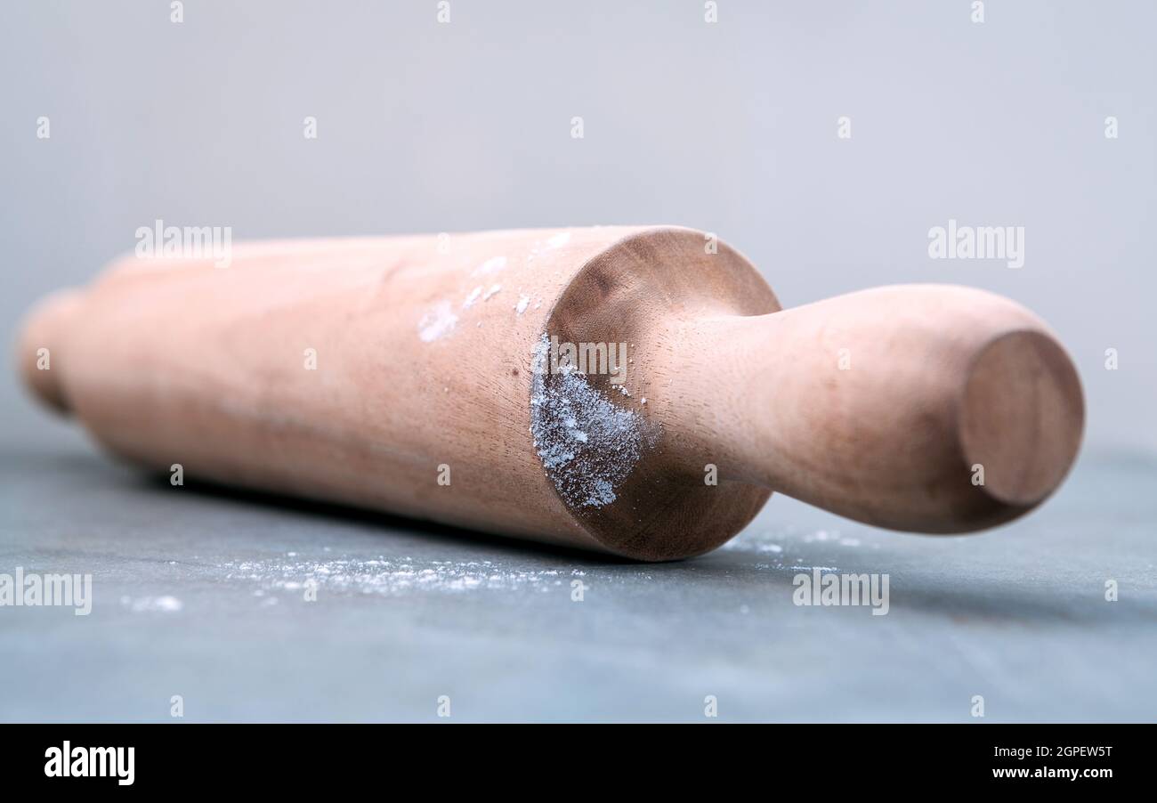 Kitchen rolling pin with flour on dark background selective focus depth ...