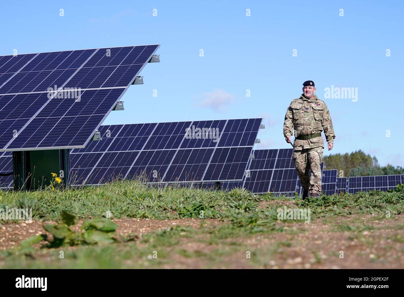 Sergeant Major Jimmy Girvan walks through a field of solar panels at ...