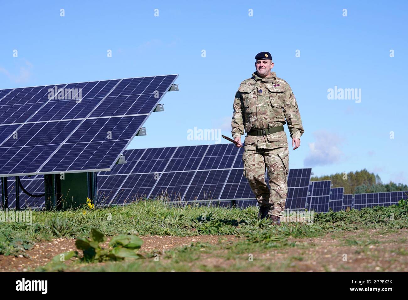Sergeant Major Jimmy Girvan walks through a field of solar panels at ...