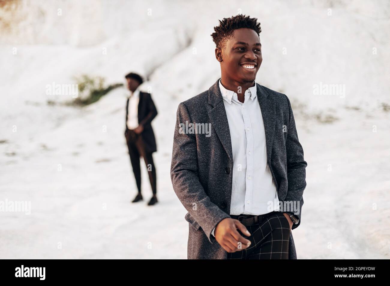 Two fashion models posing in the street, in classic clothes, suit, coat ...