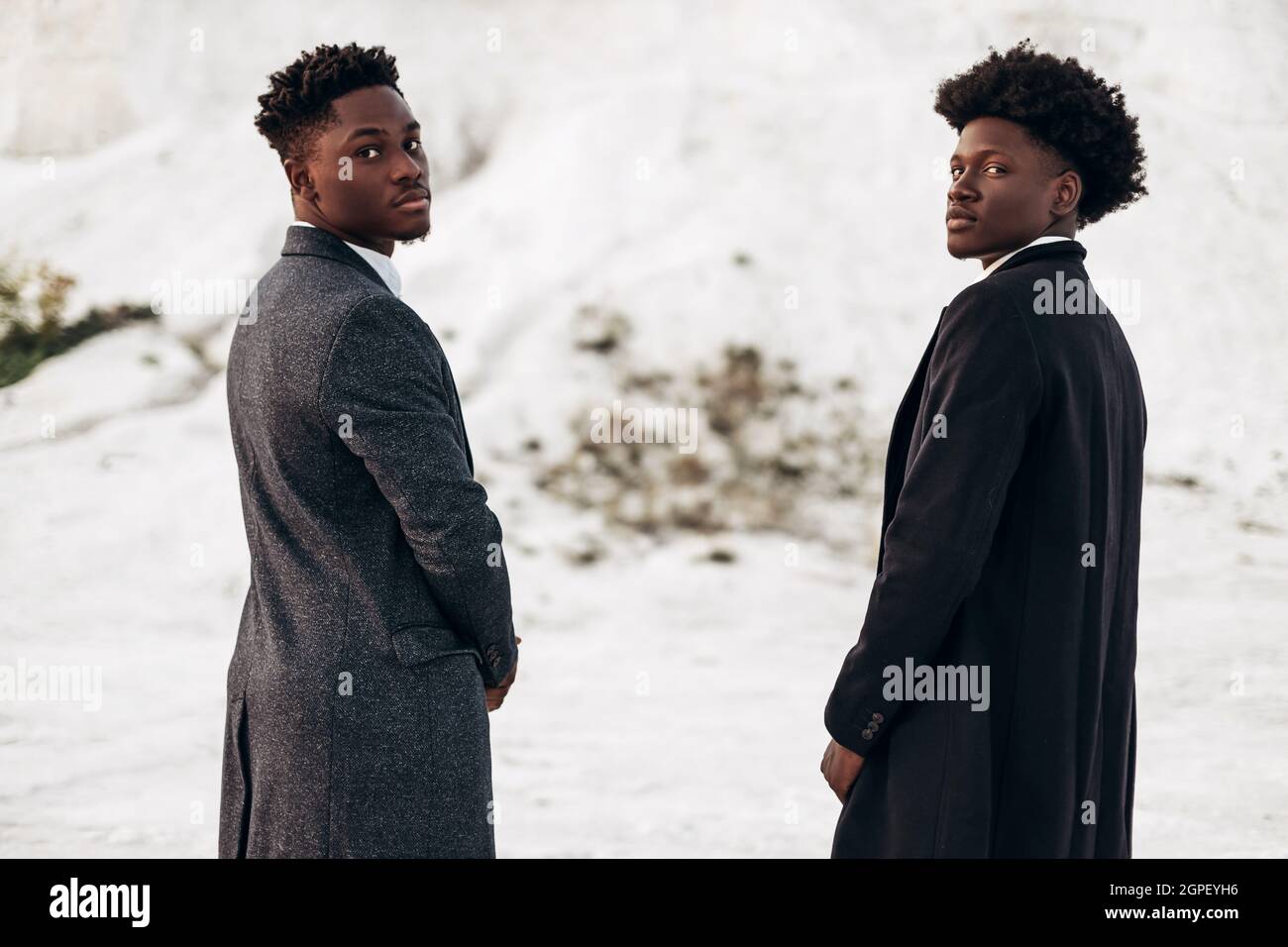 Two fashion models posing in the street, in classic clothes, suit, coat ...