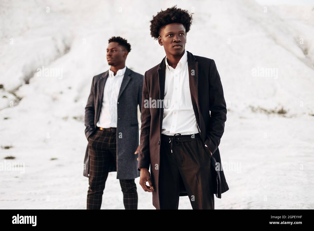 Two fashion models posing in the street, in classic clothes, suit, coat ...