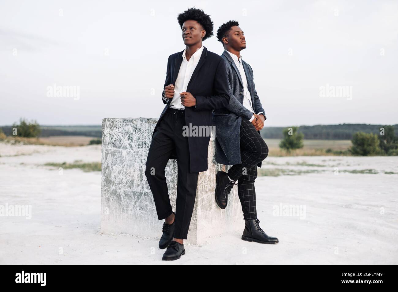 Two trendy African black men, outdoors, in stylish classic clothes ...