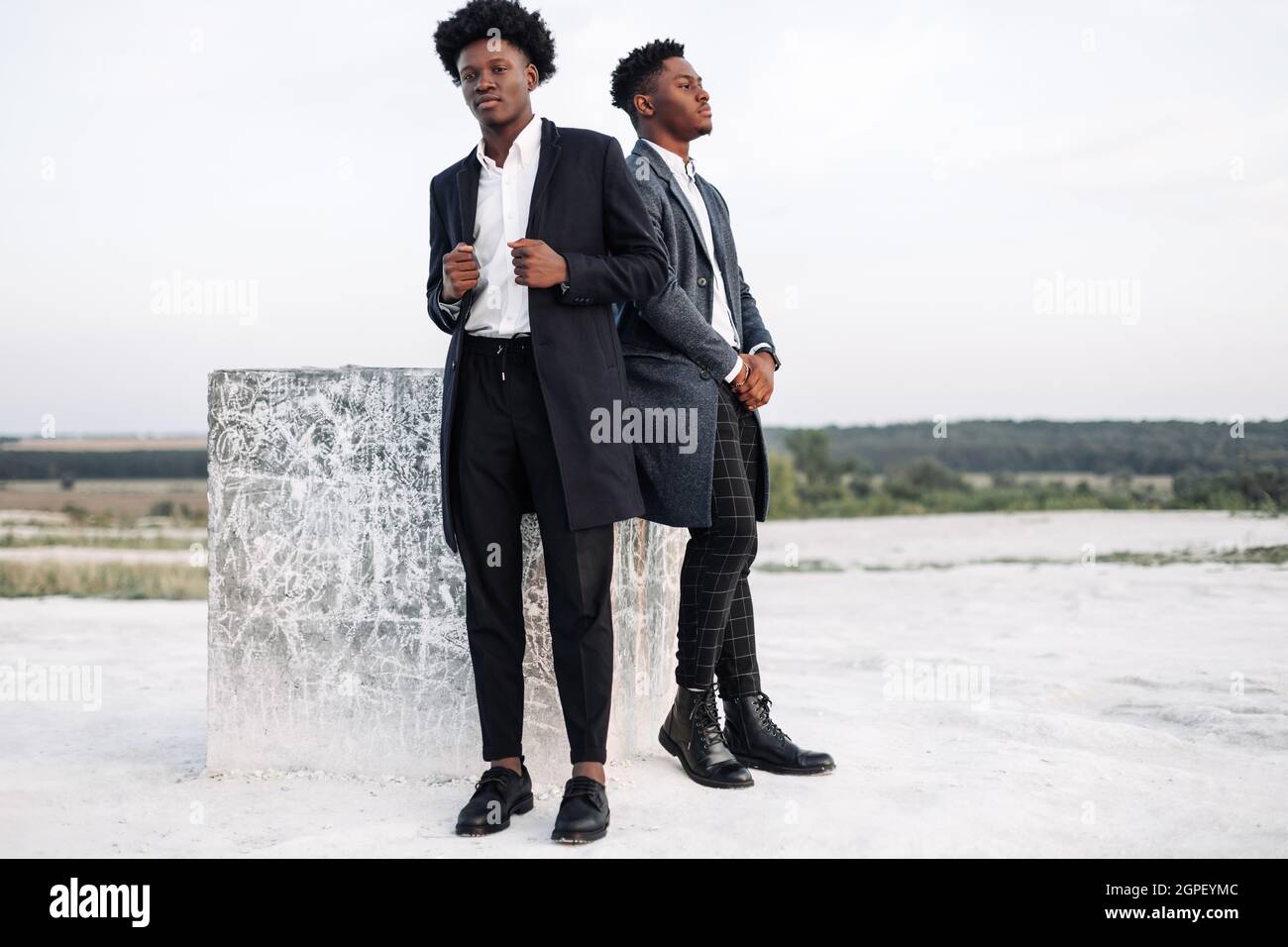 Two trendy African black men, outdoors, in stylish classic clothes ...