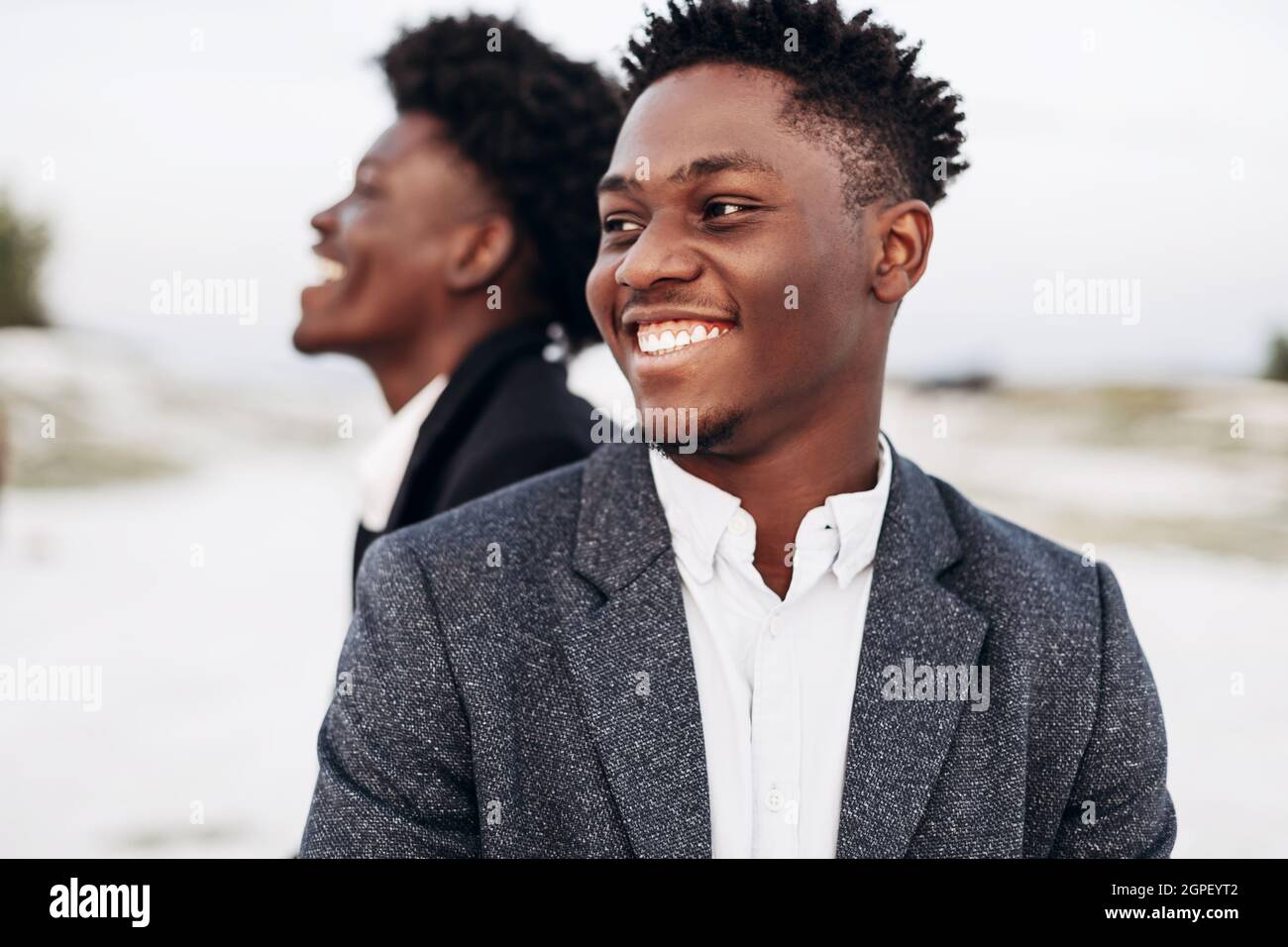 Two trendy African black men, outdoors, in stylish classic clothes ...