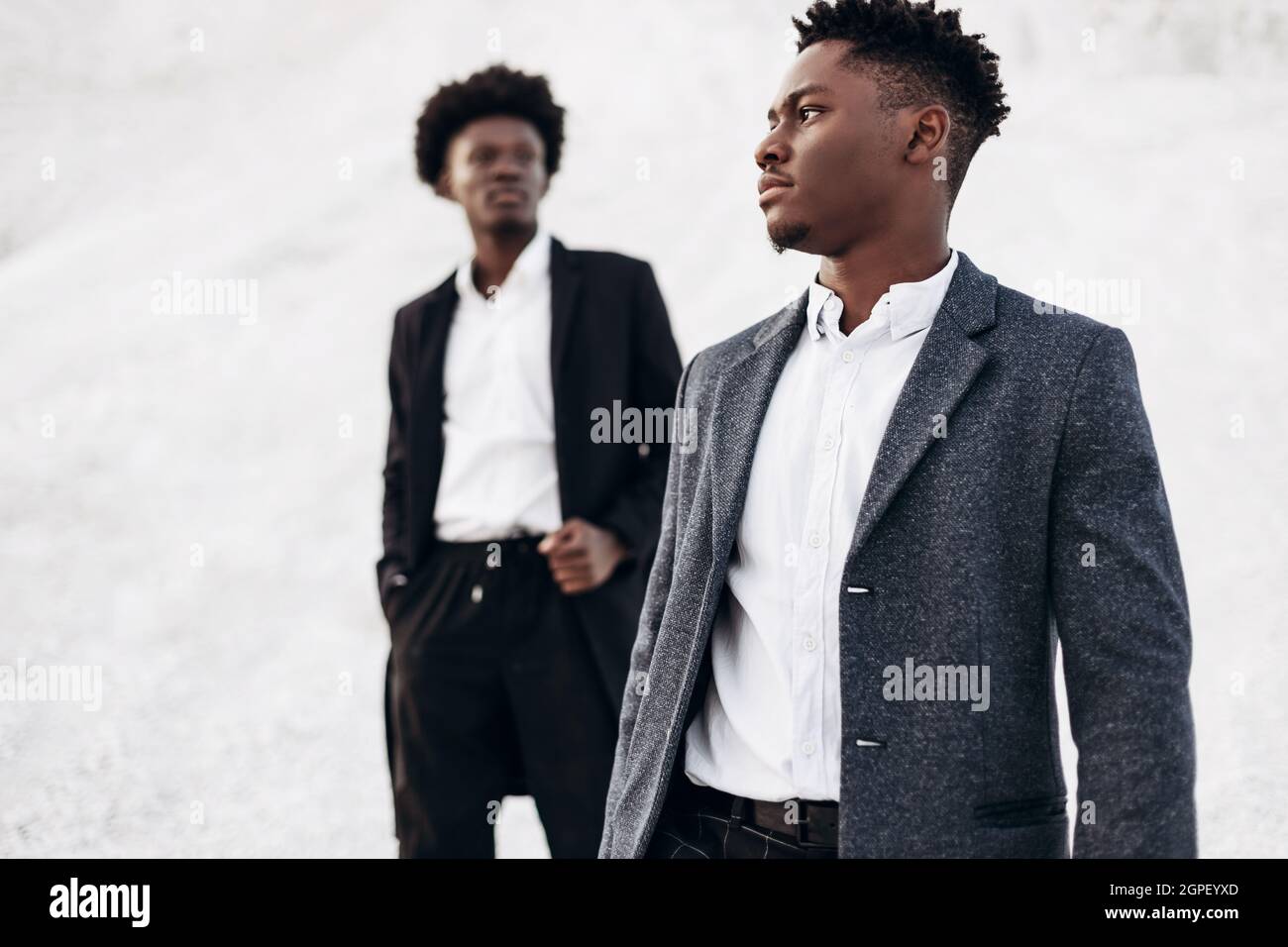 Two fashion models posing in the street, in classic clothes, suit, coat ...
