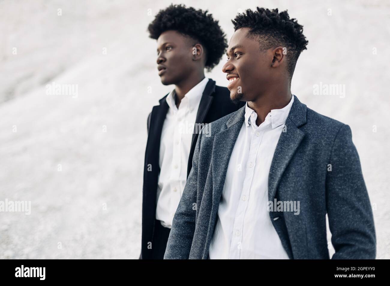 Two fashion models posing in the street, in classic clothes, suit, coat ...