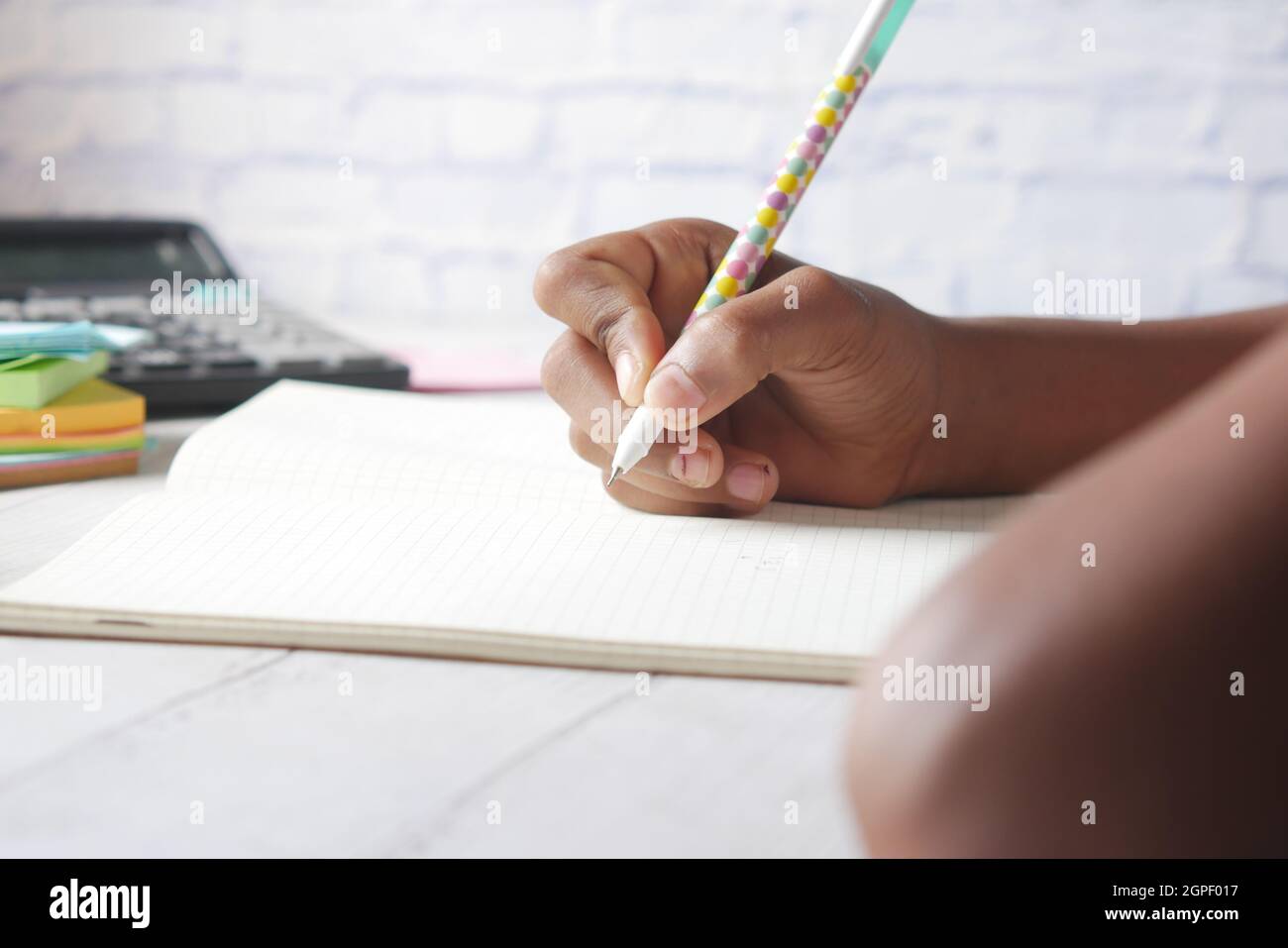 side view of child girl hand writing on notepad Stock Photo - Alamy