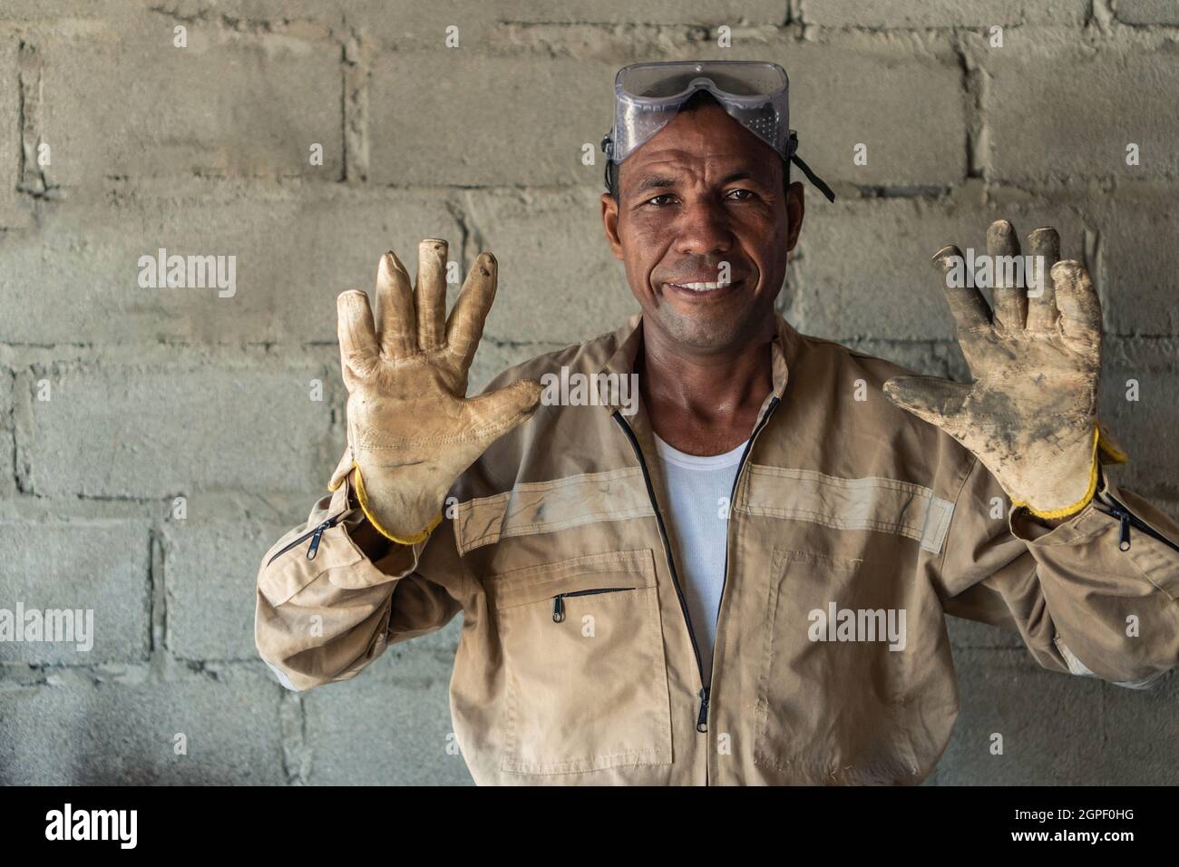 Welder standing at his work place smiling and looking at the camera ...