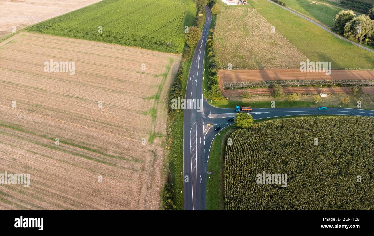Aerial view of cars moving on highway intersections in green fields ...