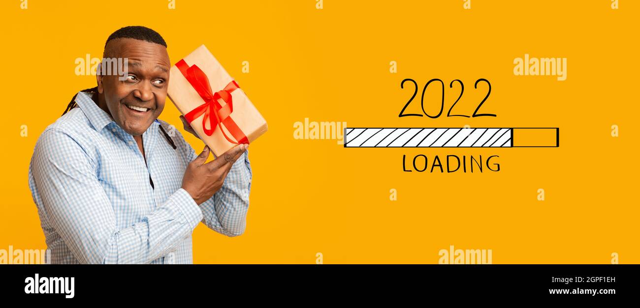 Senior black man with gift box waiting for 2022 to start on orange ...