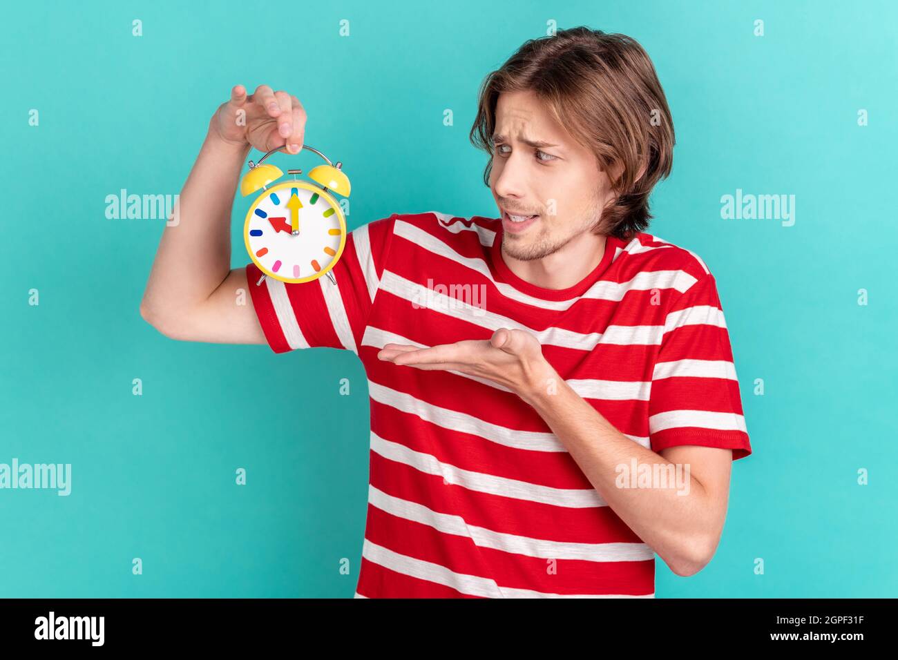 Portrait of attractive desperate guy holding retro clock late hour wake ...
