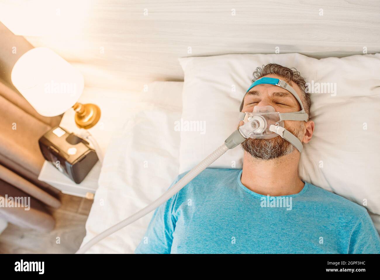 Sleeping man with chronic breathing issues considers using CPAP machine ...